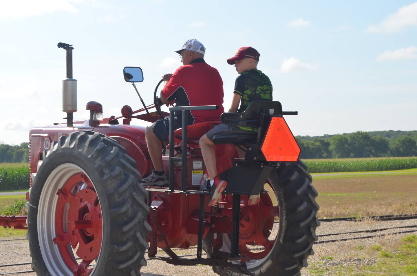 Grandpa and grandson ride together on their antique Farmall – Shaw Local